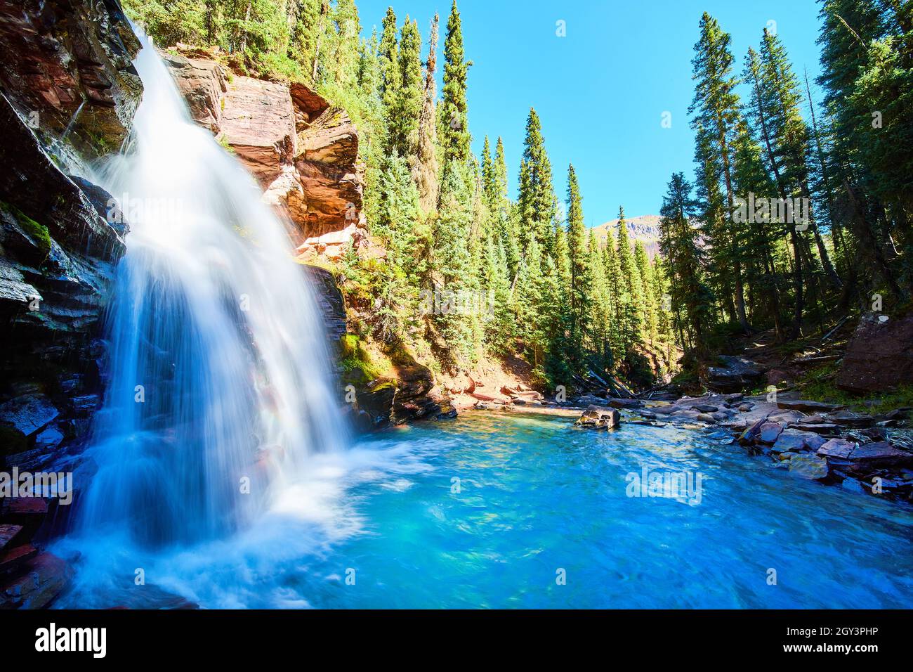View from side of scenic blue waterfall tucked into gorge in mountains ...