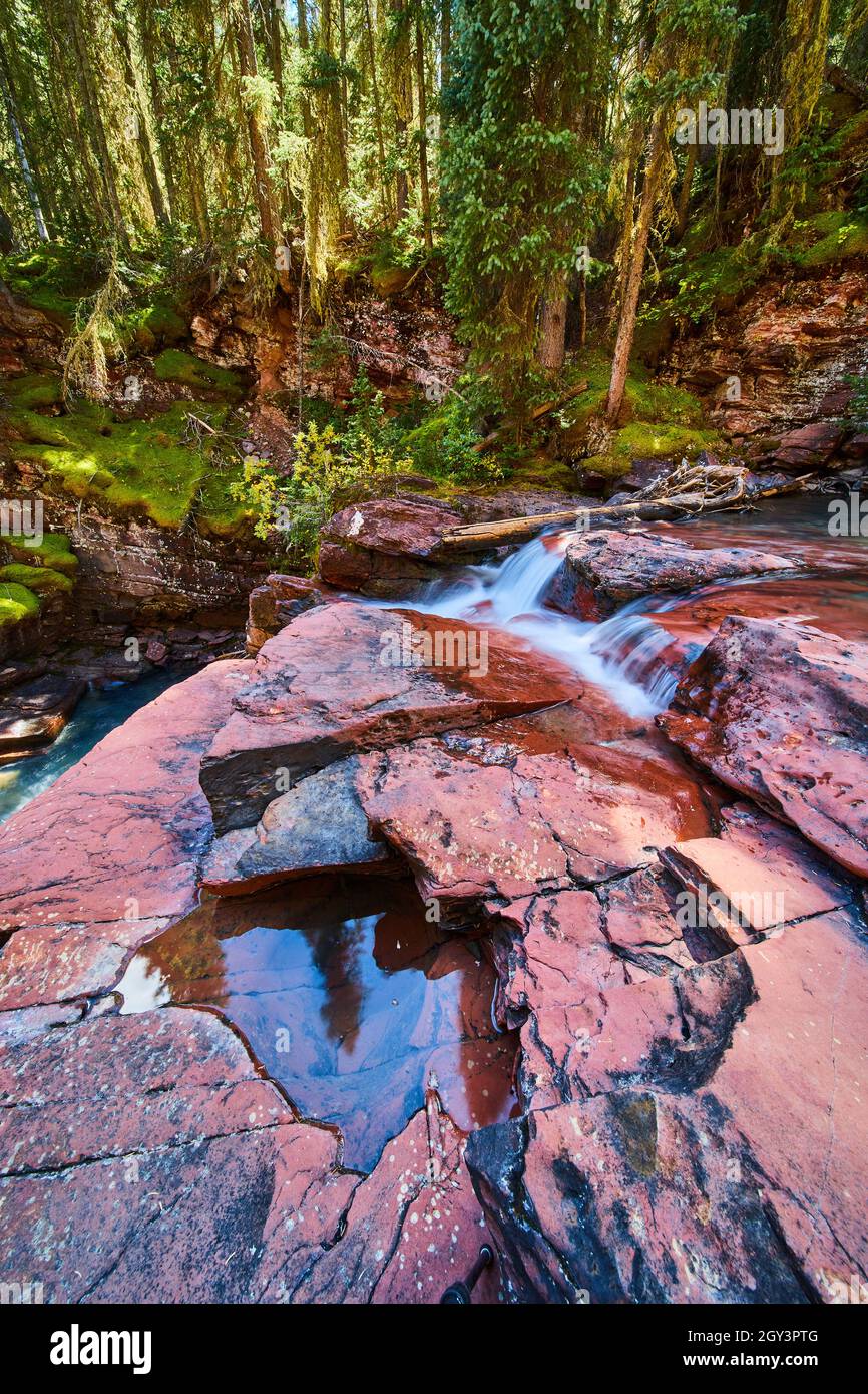 Red rocks with buckets of water and small waterfalls with cliffs of ...
