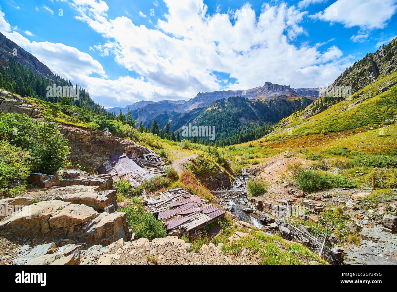 Collapsed structures next to river in the valley of a large mountain ...