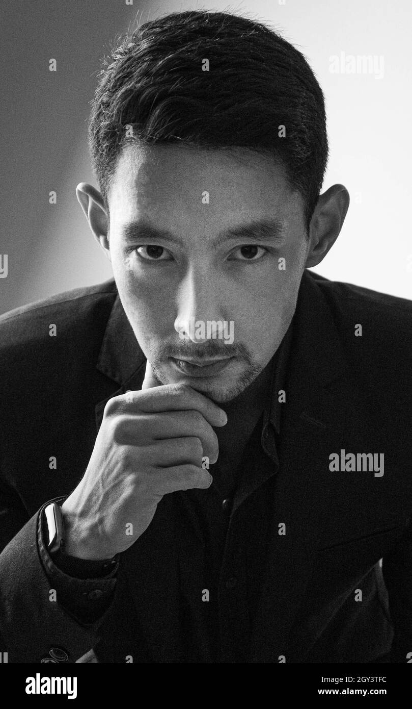 Grayscale portrait of a handsome thoughtful East Asian man with a beard ...