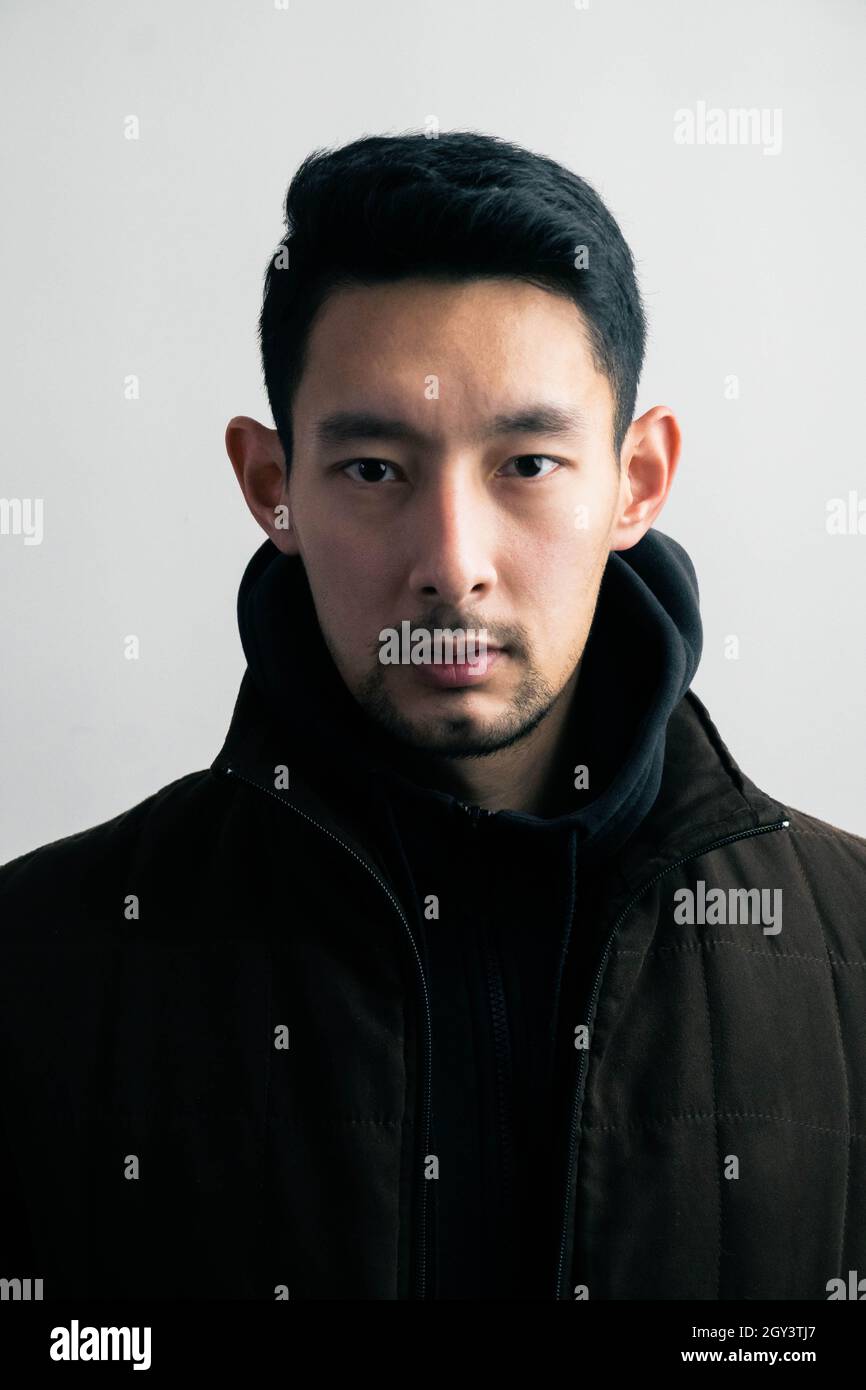 Portrait of a handsome East Asian man with a beard wearing a hoodie ...