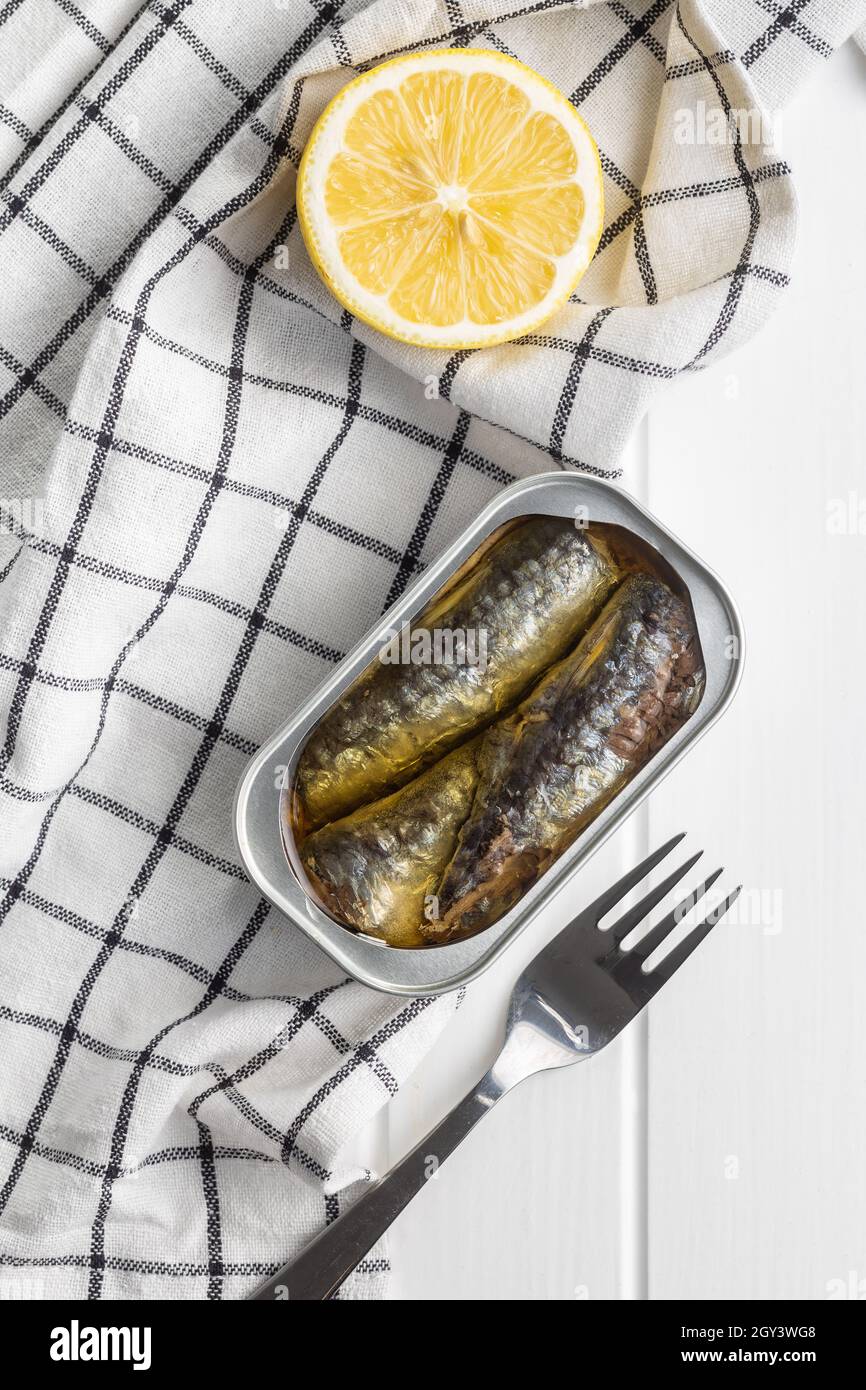 Canned sardines. Sea fish in tin can on white wooden table. Top view ...