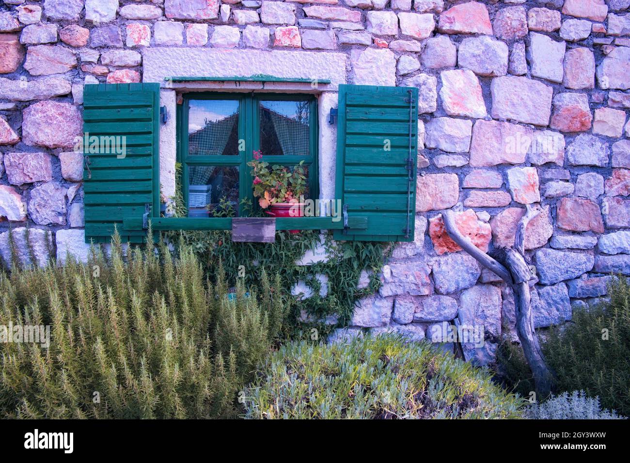 Traditional Mediterranean house with open wooden window and stone wall ...