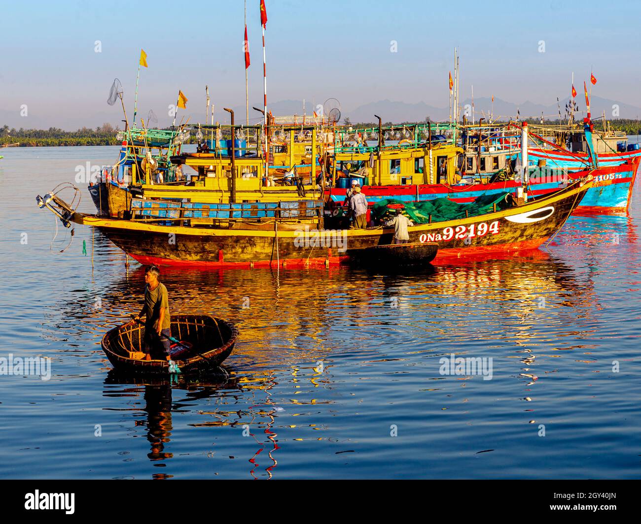 A large group of fishing boats all stacked up next to each other as one ...