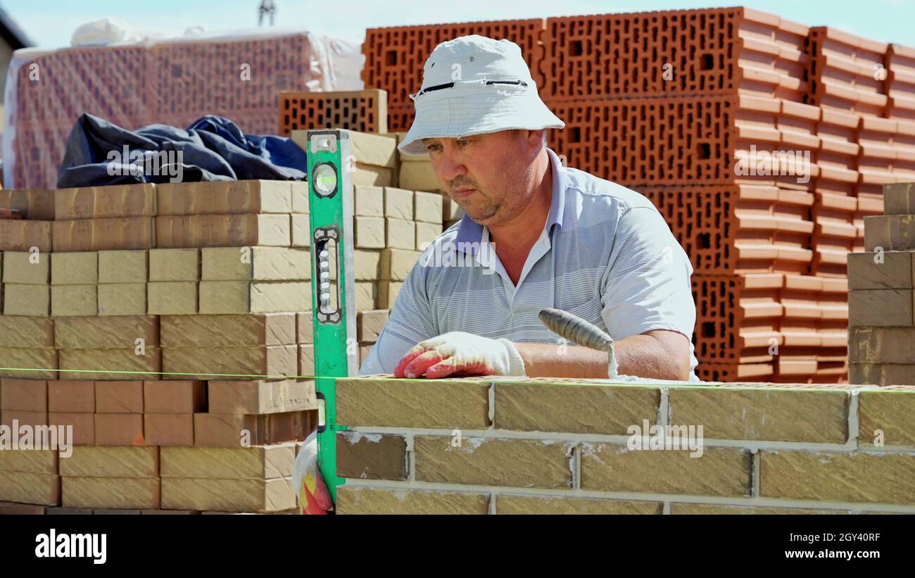 Close up of construction worker's hand pressing brick into place Stock ...