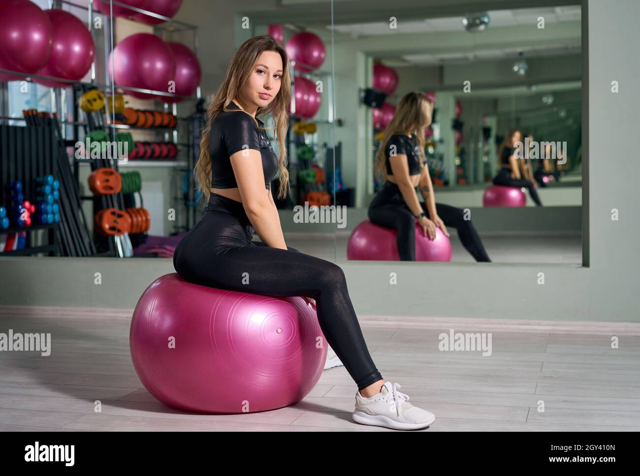 Young woman trainer making squats on bosu balance ball Stock Photo - Alamy