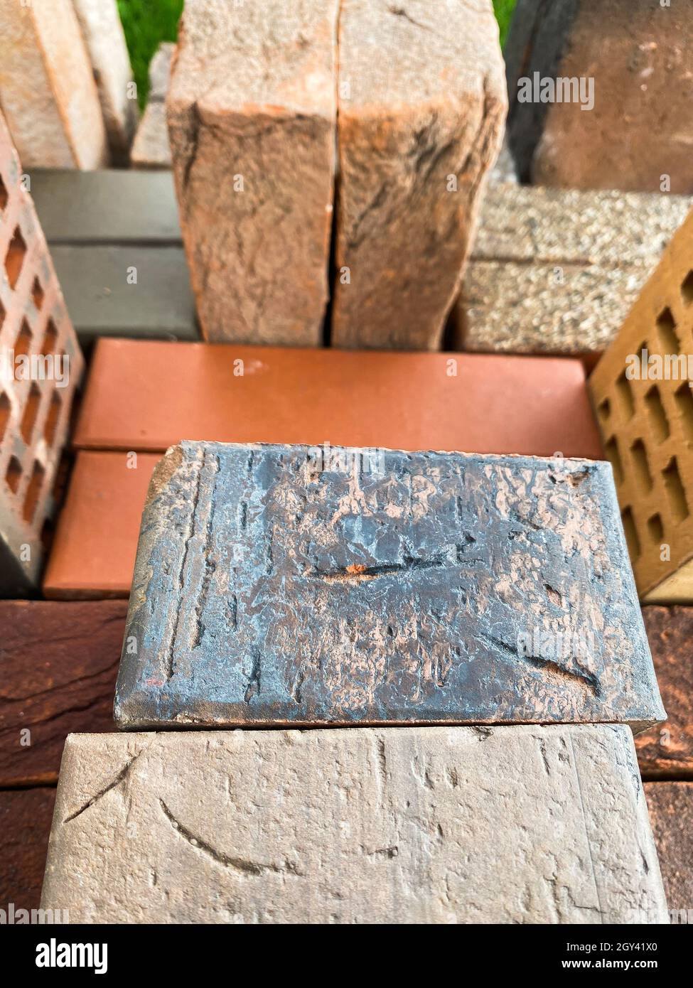 Different types of bricks stacked beautifully on green grass Stock ...