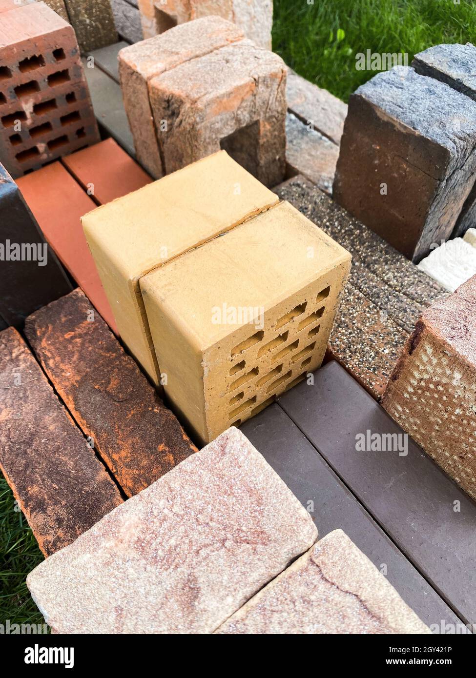 Different types of bricks stacked beautifully on green grass Stock ...