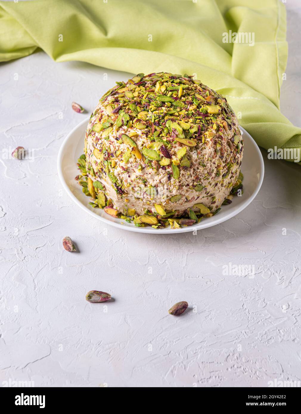 Sesame halva with pistachios on top, few scattered nuts, green linen ...