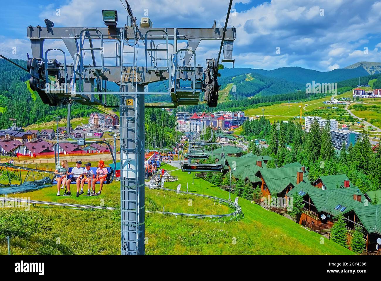 BUKOVEL, UKRAINE - JULY 25, 2021: The skilift, riding along the green ...