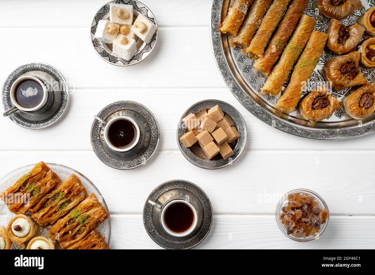 Top view of Turkish sweets and Turkish coffee on white wooden ...