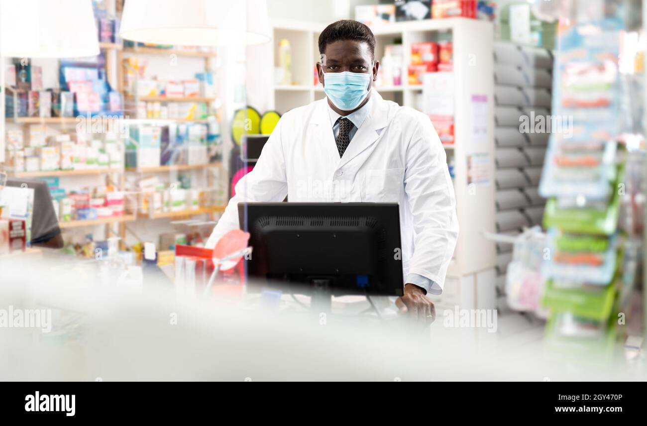 Portrait of an african american male pharmacist in a protective mask ...