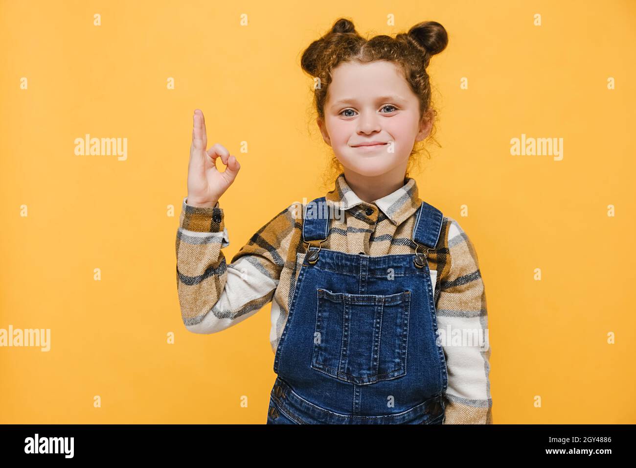 Portrait of little girl child shows ok sign, agrees with something and ...