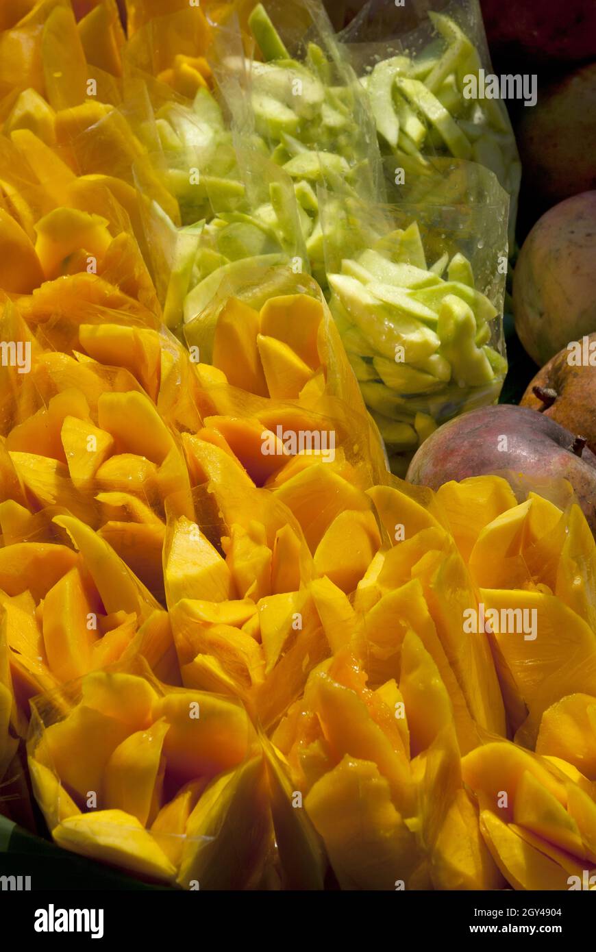 Fresh mango, fruit sliced in plastic bags in a street market. Guatemala ...