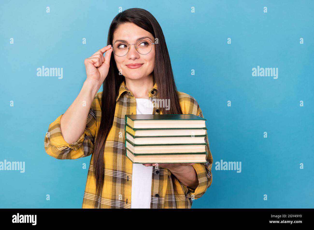 Portrait of attractive cheerful girl librarian holding book library ...