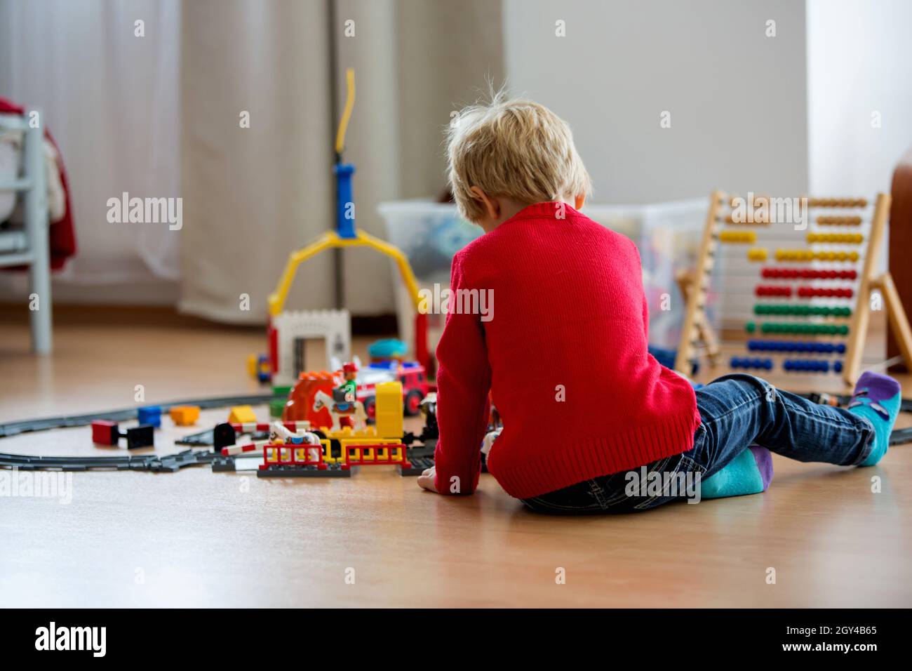 Cute child, playing with colorful toy blocks. Little boy building house ...