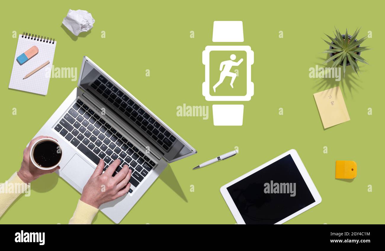 Top view of hands using laptop with symbol of wearable technology ...