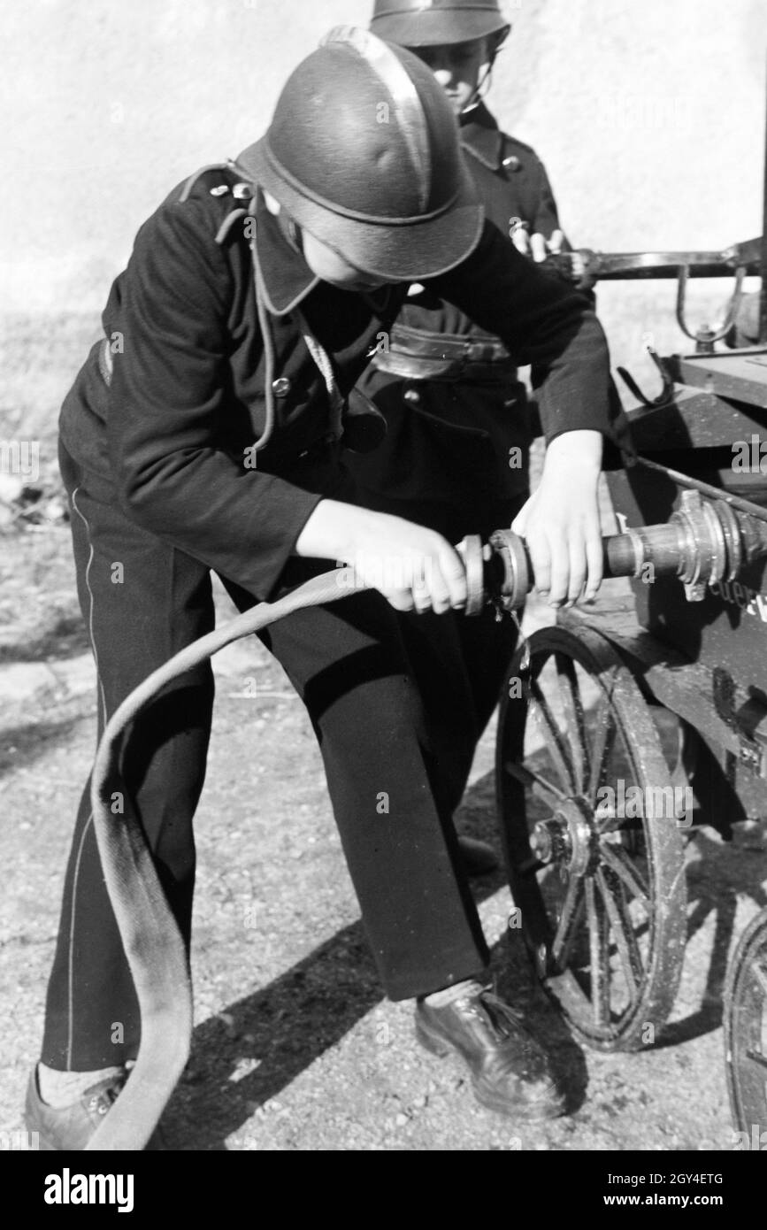 Zwei uniformierte Jungen von der Kinderfeuerwehr installieren bei einer ...