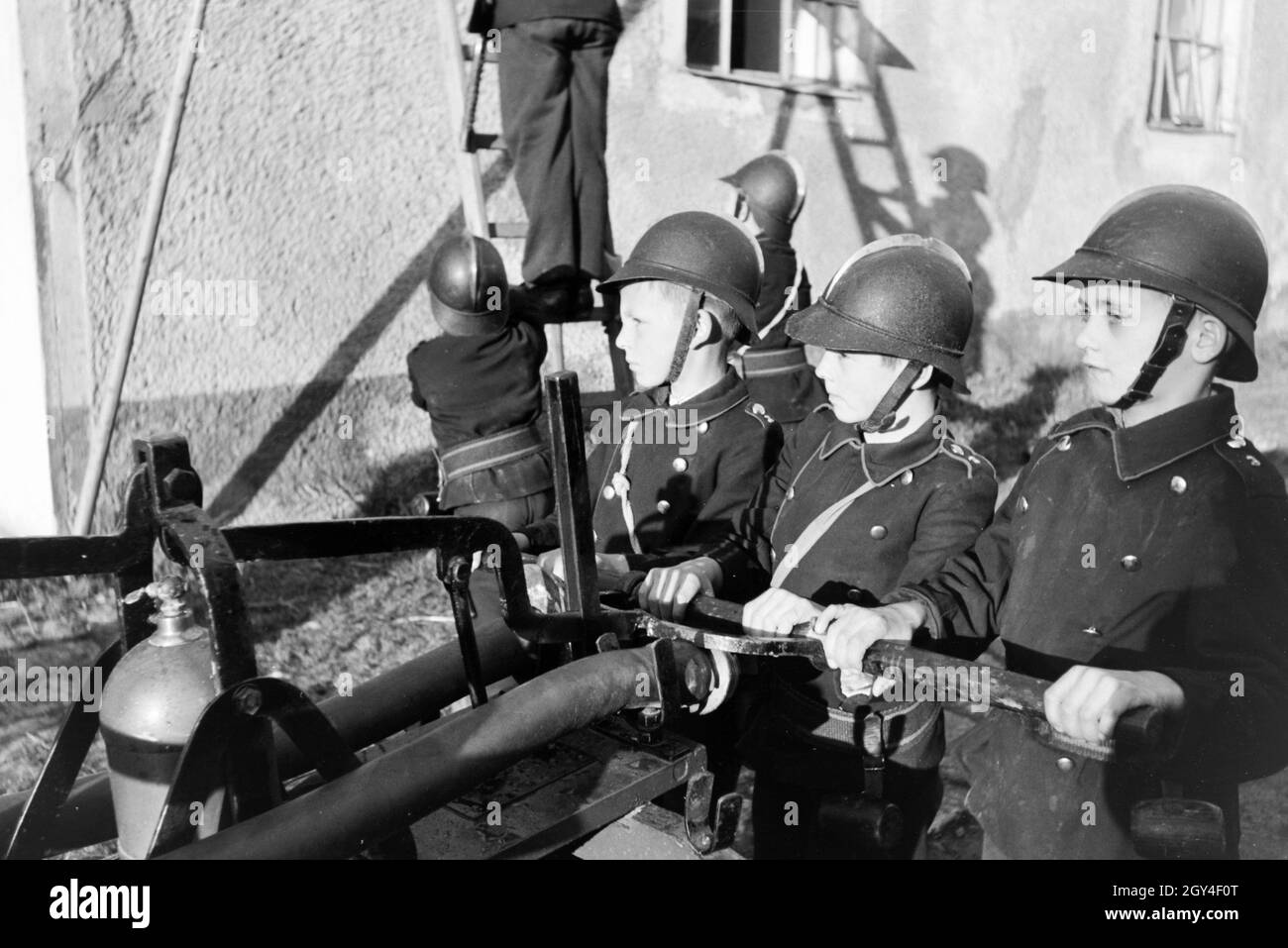 Eine Gruppe von der Kinderfeuerwehr mit dem Löschwagen und der Leiter ...