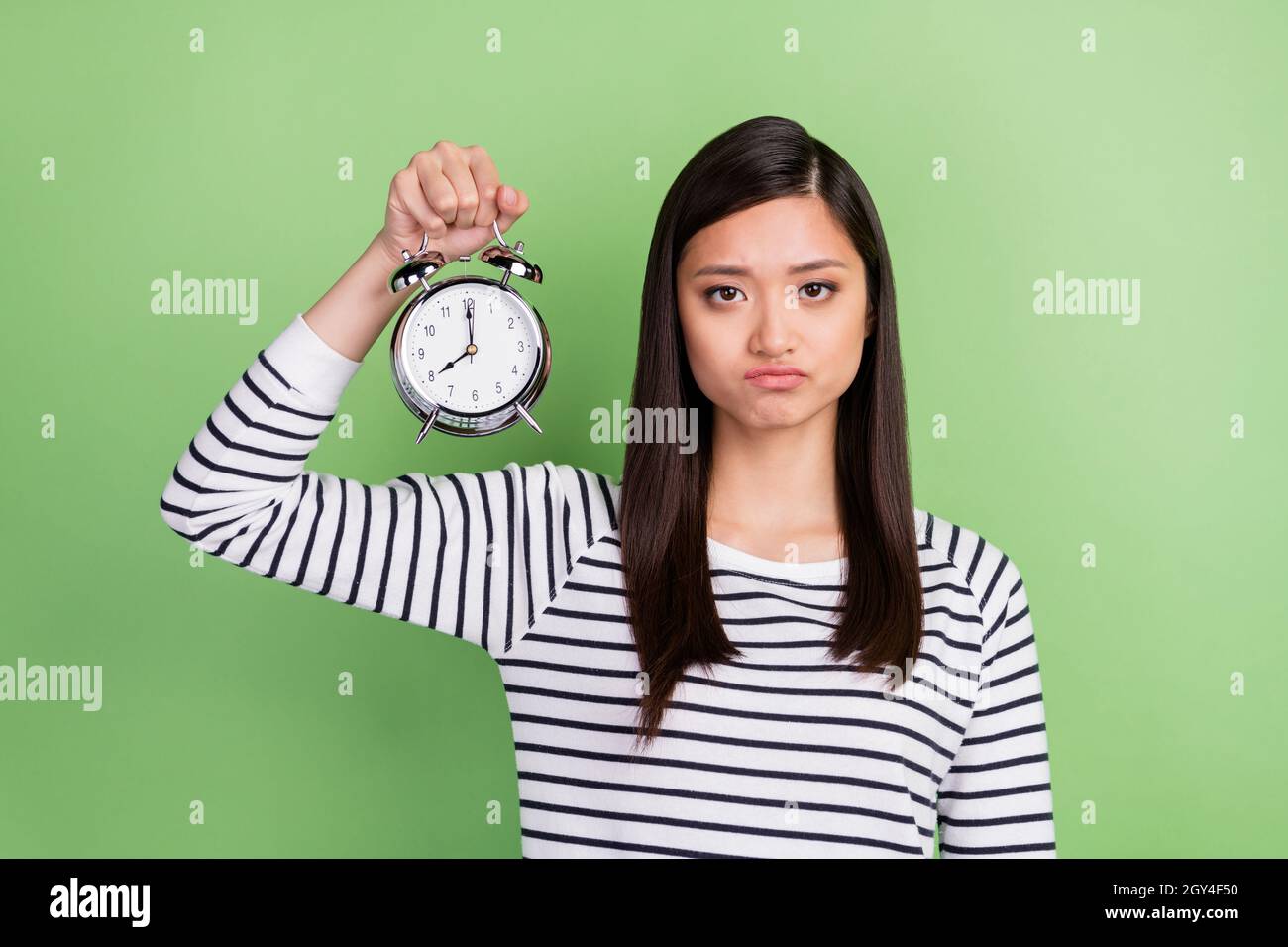 Portrait of attractive depressed tired girl holding in hands clock ...