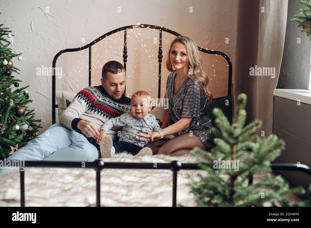Loving parents cuddling their child on bed during holidays Stock Photo ...