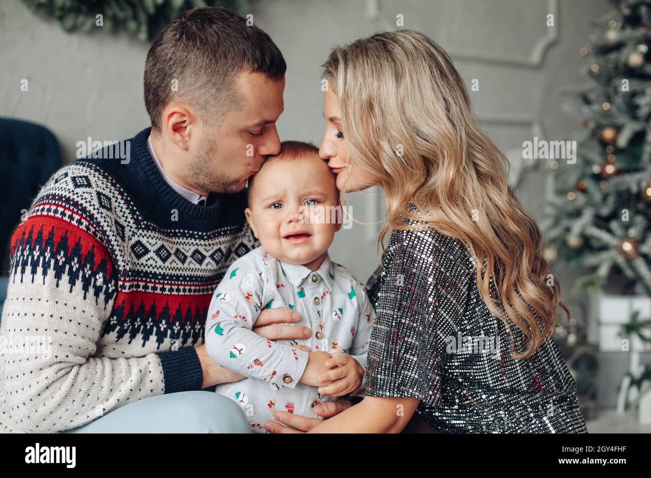 Young parents showing affection to their cute kid Stock Photo - Alamy