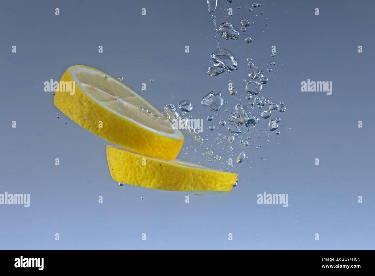 Lemon wedges falling into the water with splashing Stock Photo - Alamy