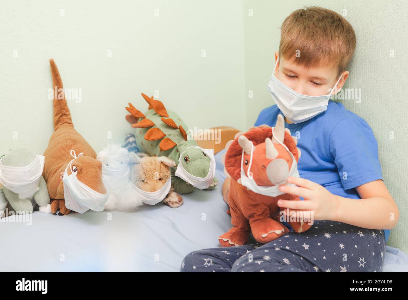 Child plays role-playing games. Baby bay and his dinosaurs toys wearing ...