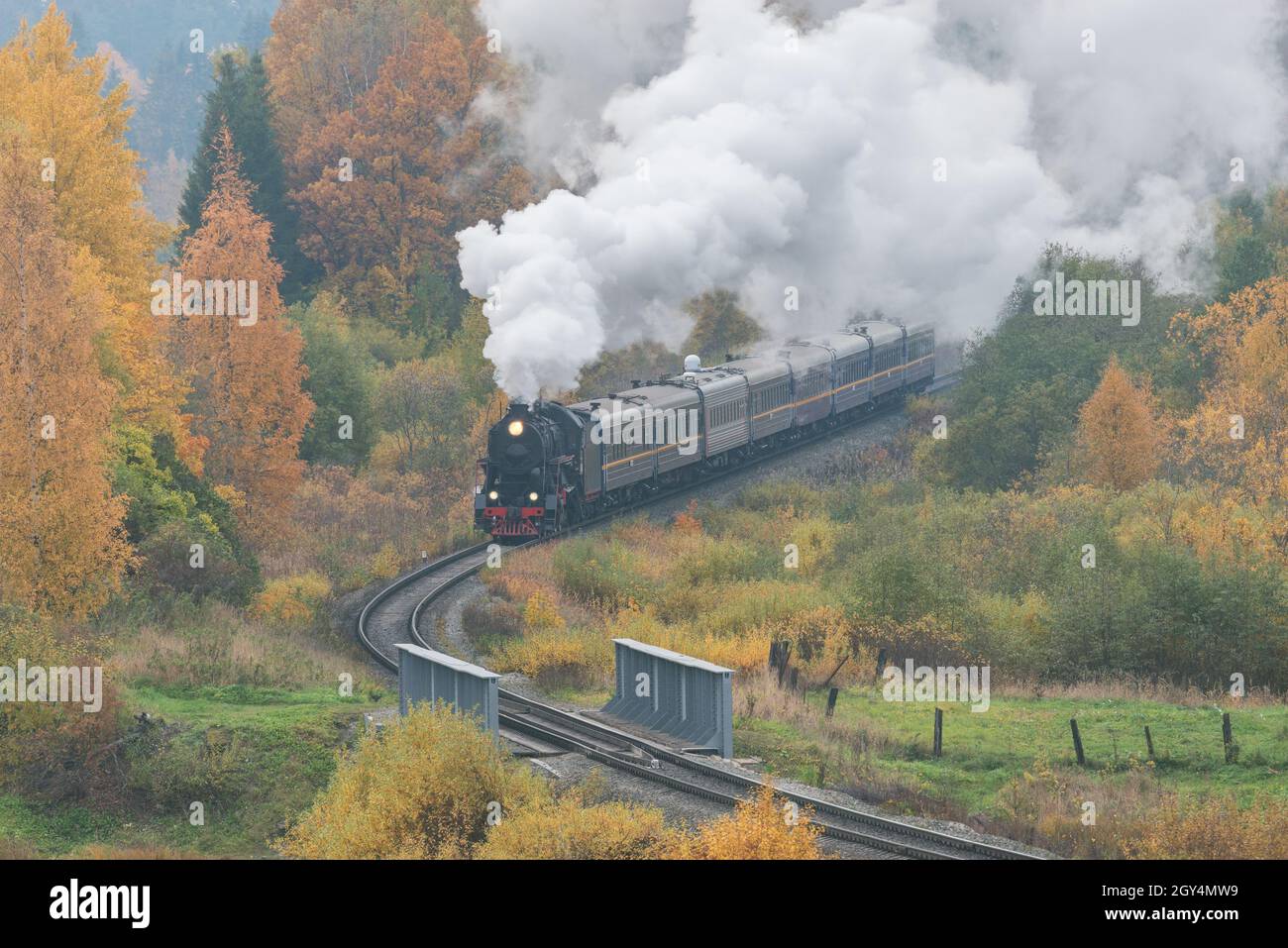 Retro steam train approaches to the station at autumn morning Stock ...
