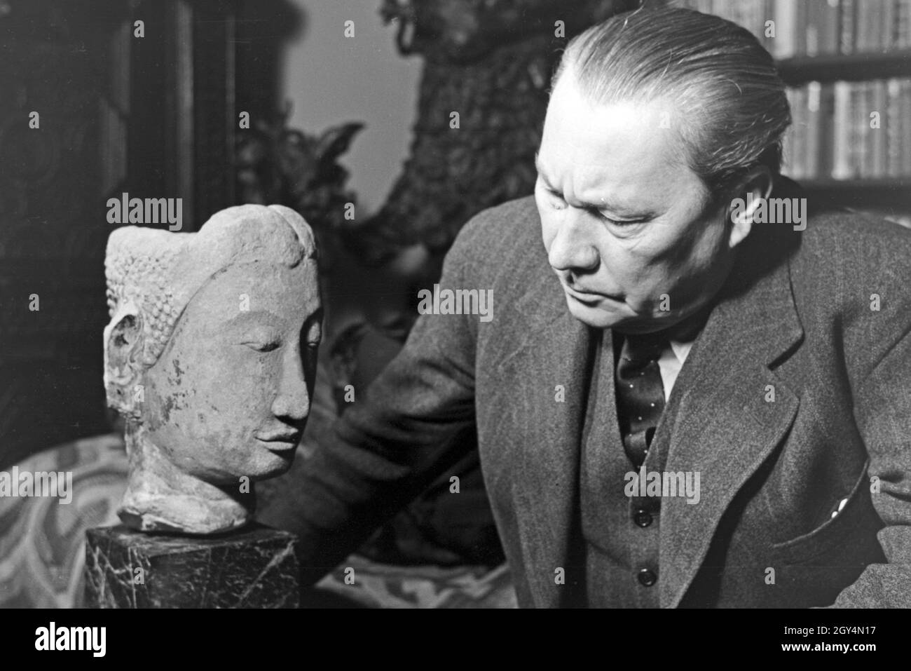 Der deutsche Schauspieler Paul Wegener mit dem Kopf einer Buddhastatue ...