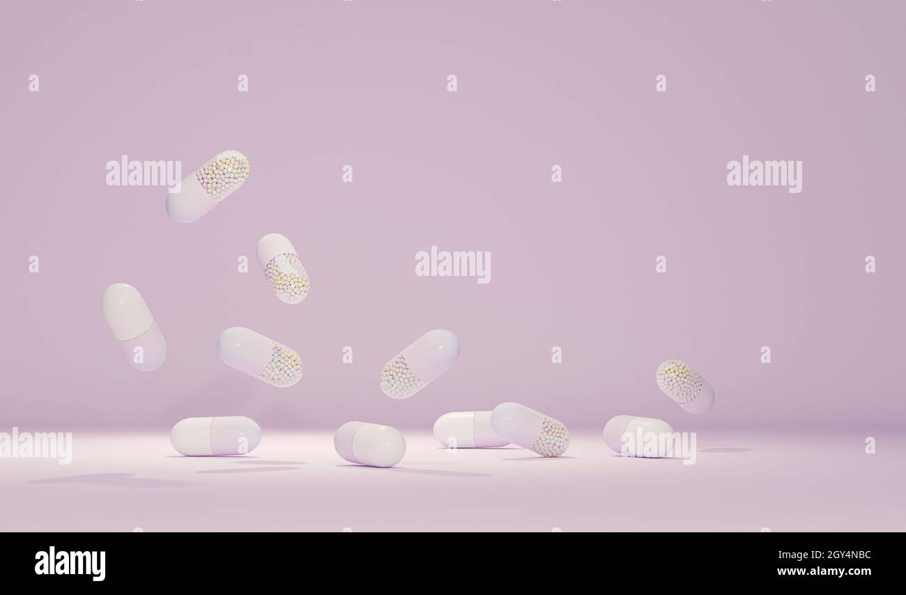 A group of antibiotic pill capsules falling on pastel pink background ...