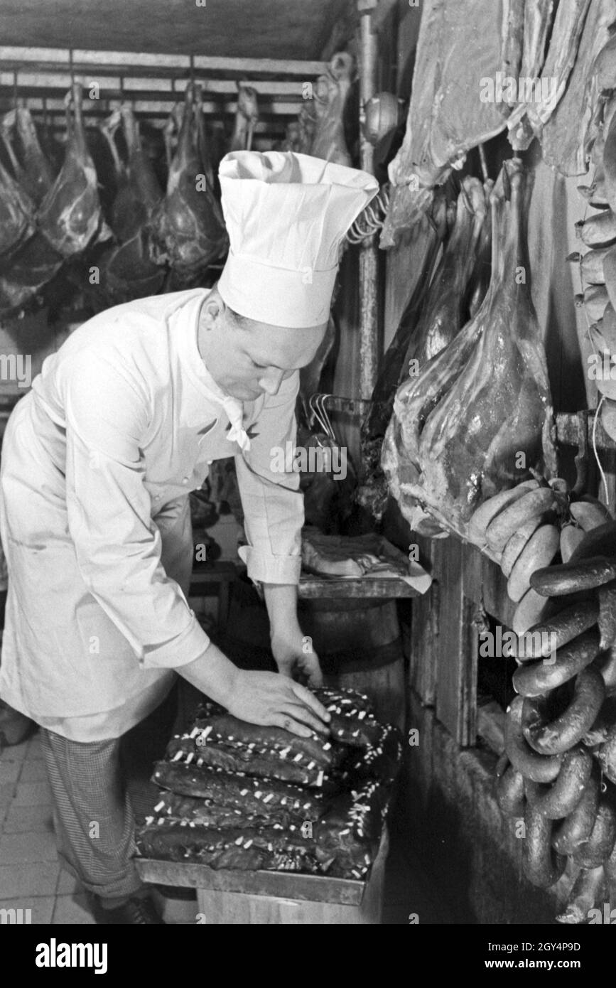 Ein Koch beim Fleisch im Kühlraum in der Küche einer Gaststätte ...