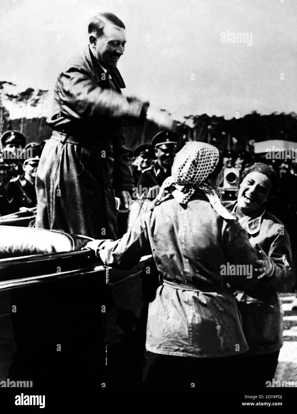 A laughing Adolf Hitler doing the Hitler salute with likewise laughing ...