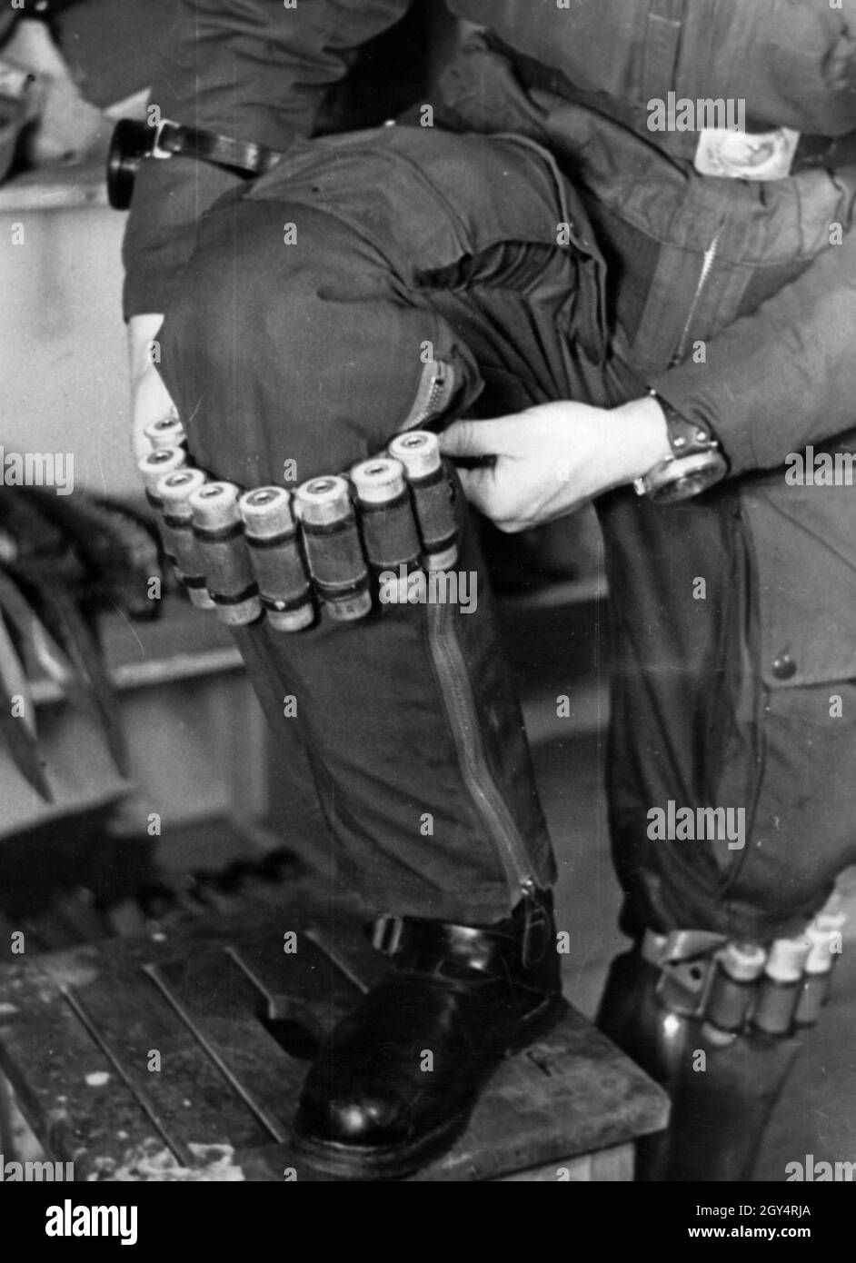 A German pilot ties a leather strap with signal ammunition around each ...