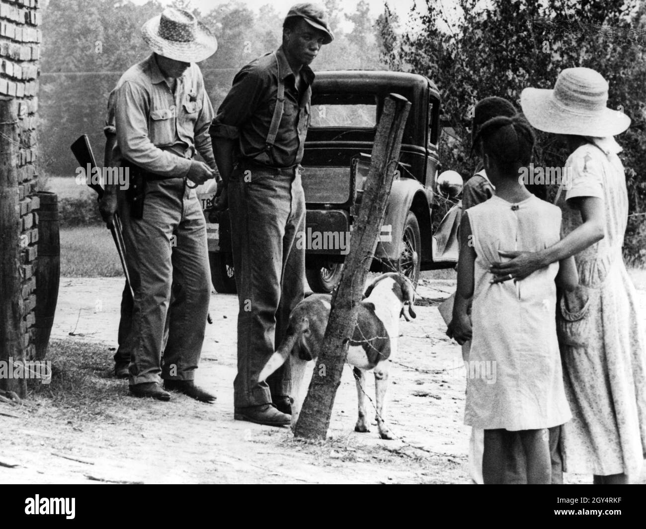 Police officers arrest an African-American farm worker in the US ...