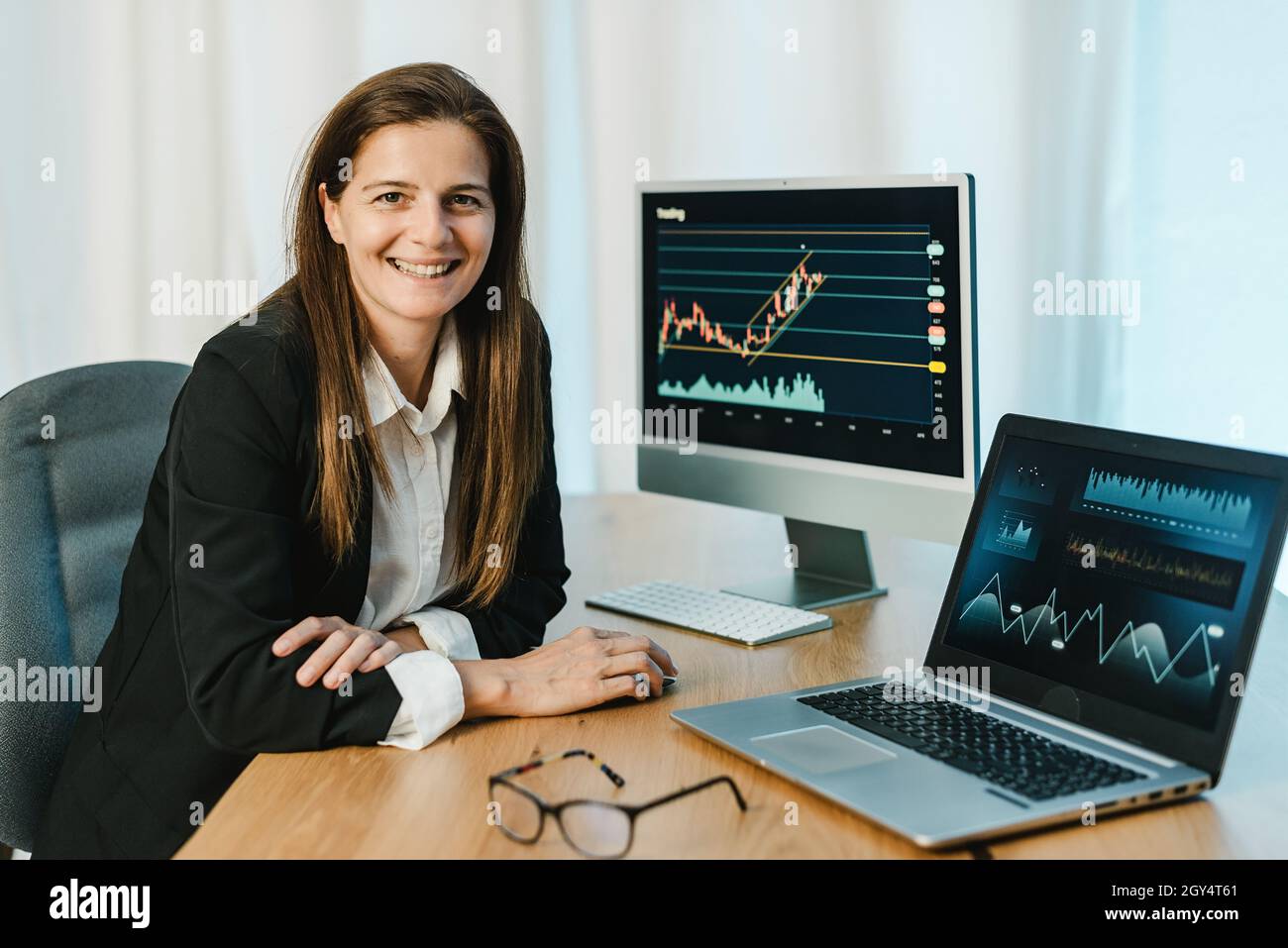 Cheerful woman trading on binary option in office Stock Photo - Alamy