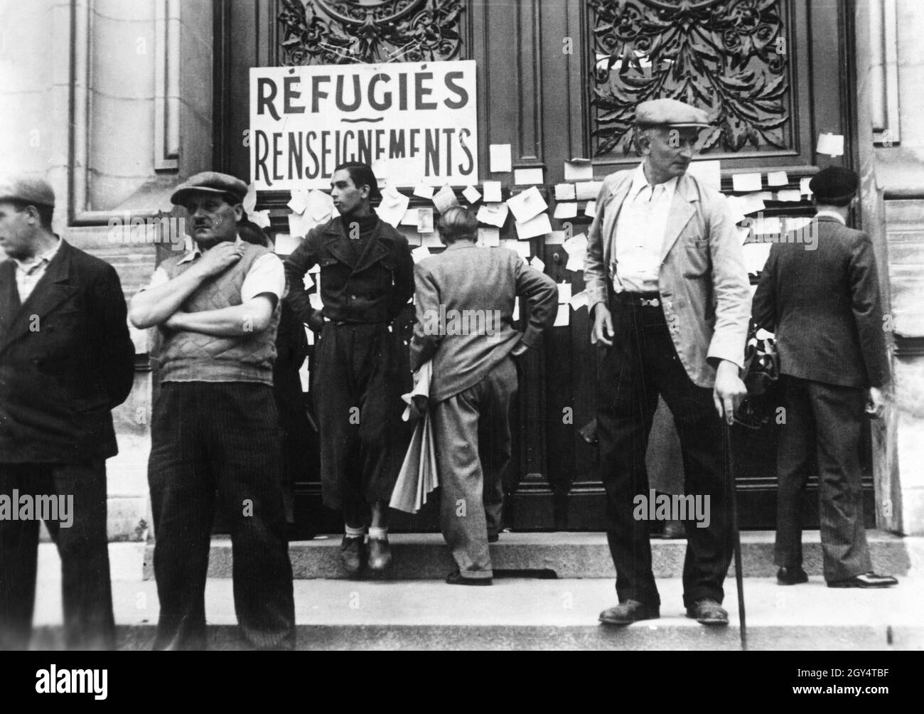 Frenchmen gathered in front of a large door in Poitiers on the day of ...