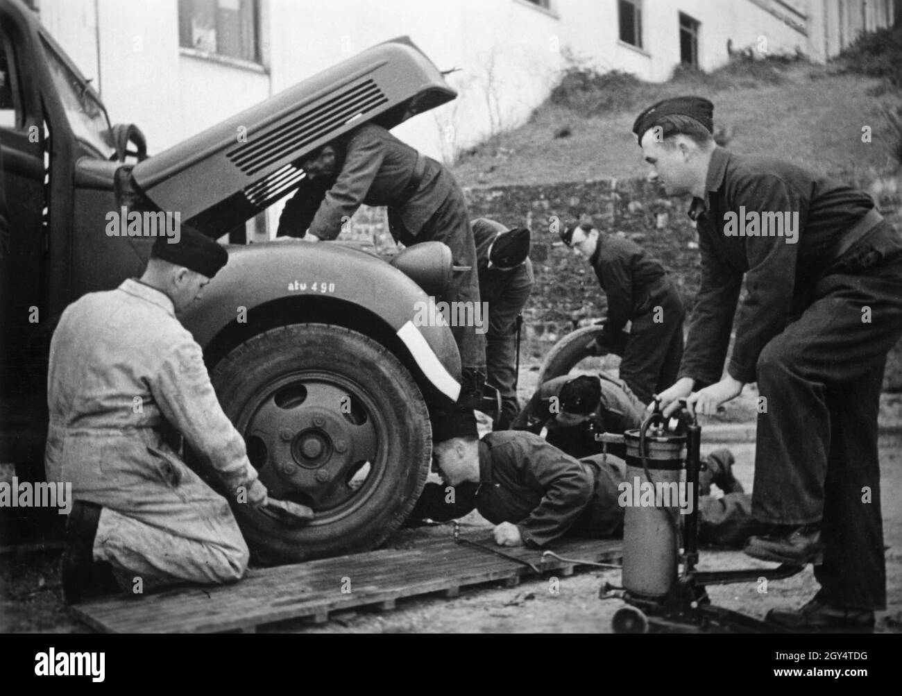 Alsatians repair a car together with men from the NSKK (National ...