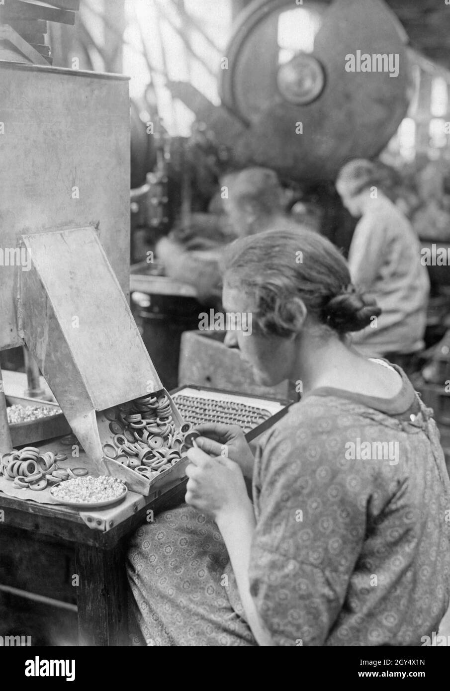 Worker making toy cars in a German toy factory. [automated translation ...