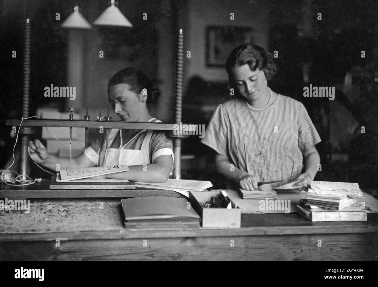 Two workers binding a book in the Maria Lühr bookbinding workshop in ...