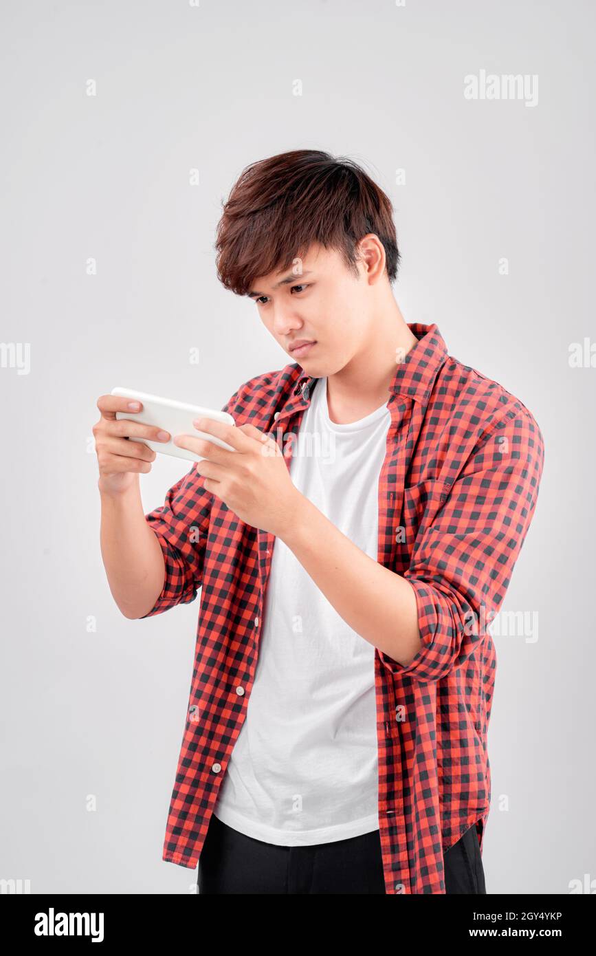 Image of an expressive young man looking at his cell phone Stock Photo ...