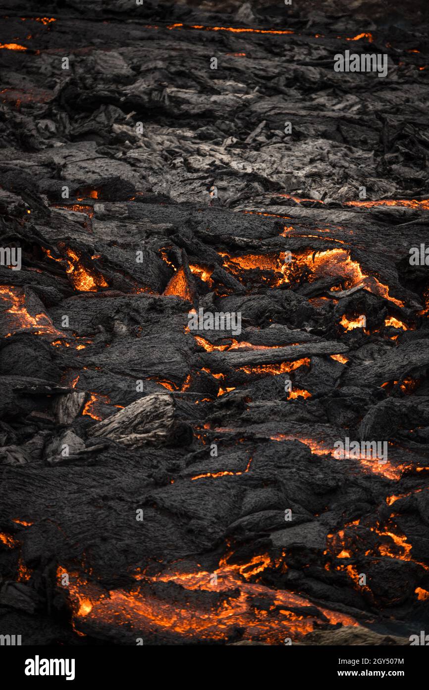 Mesmerizing vertical shot of lava flowing over the bumpy mountain Stock ...
