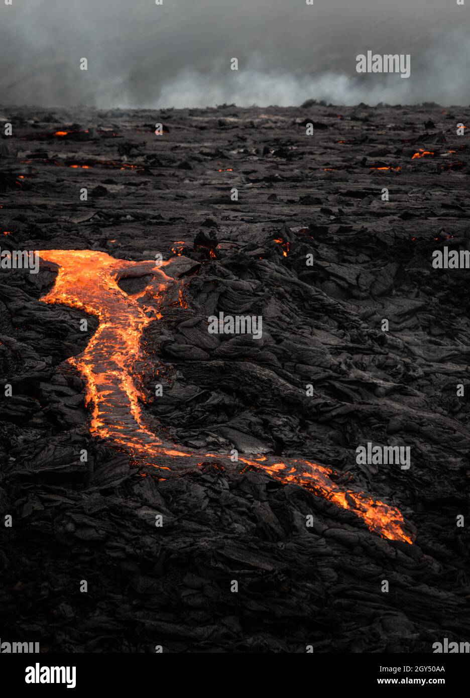 Mesmerizing vertical shot of lava flowing over the bumpy mountain Stock ...
