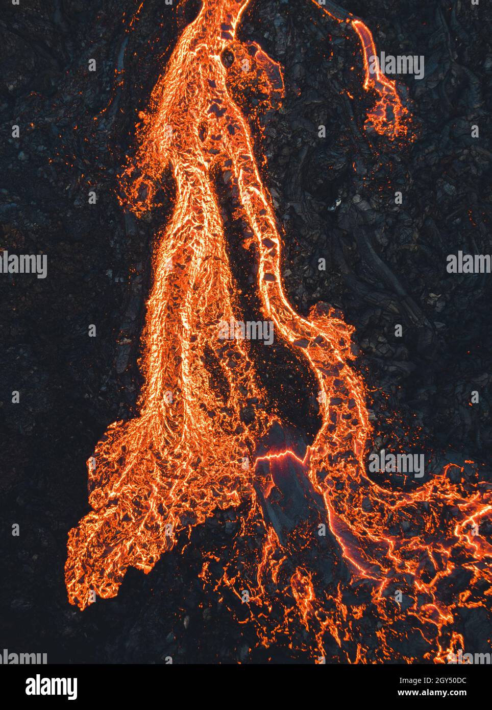 Mesmerizing vertical shot of lava flowing over the bumpy mountain Stock ...
