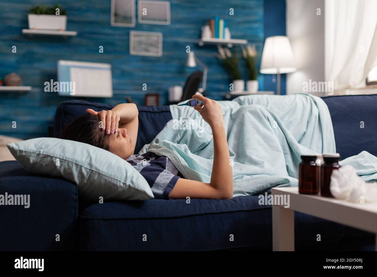 Caucasian woman feeling sick measuring temperature with digital ...