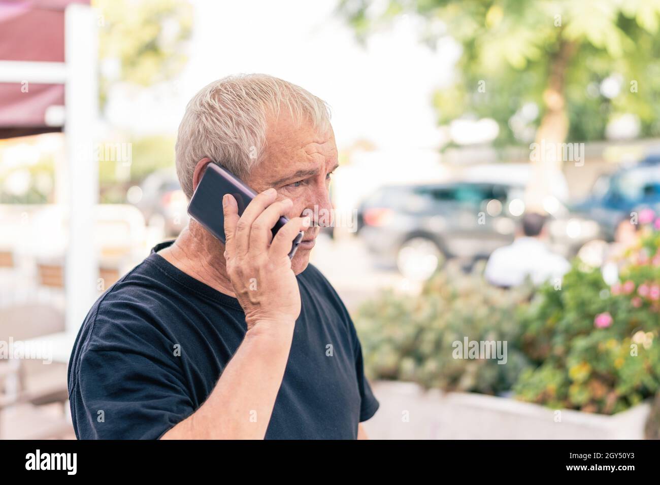 Old man talking with the mobile phone in the street Stock Photo - Alamy