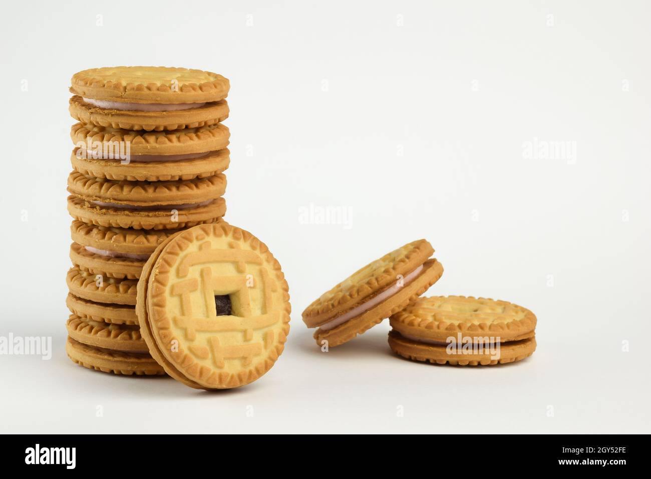 Stack of cookies on a white clipping background. One cookie is leaning ...
