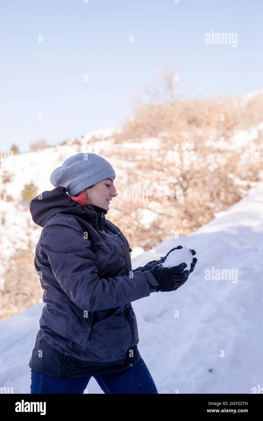 Young woman in the snow mountains landscape on holiday holding natural ...