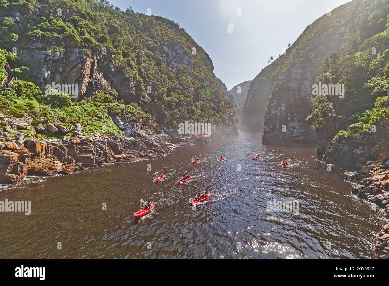 A view of Storms River Gorge with a group of kayakers in the river at ...