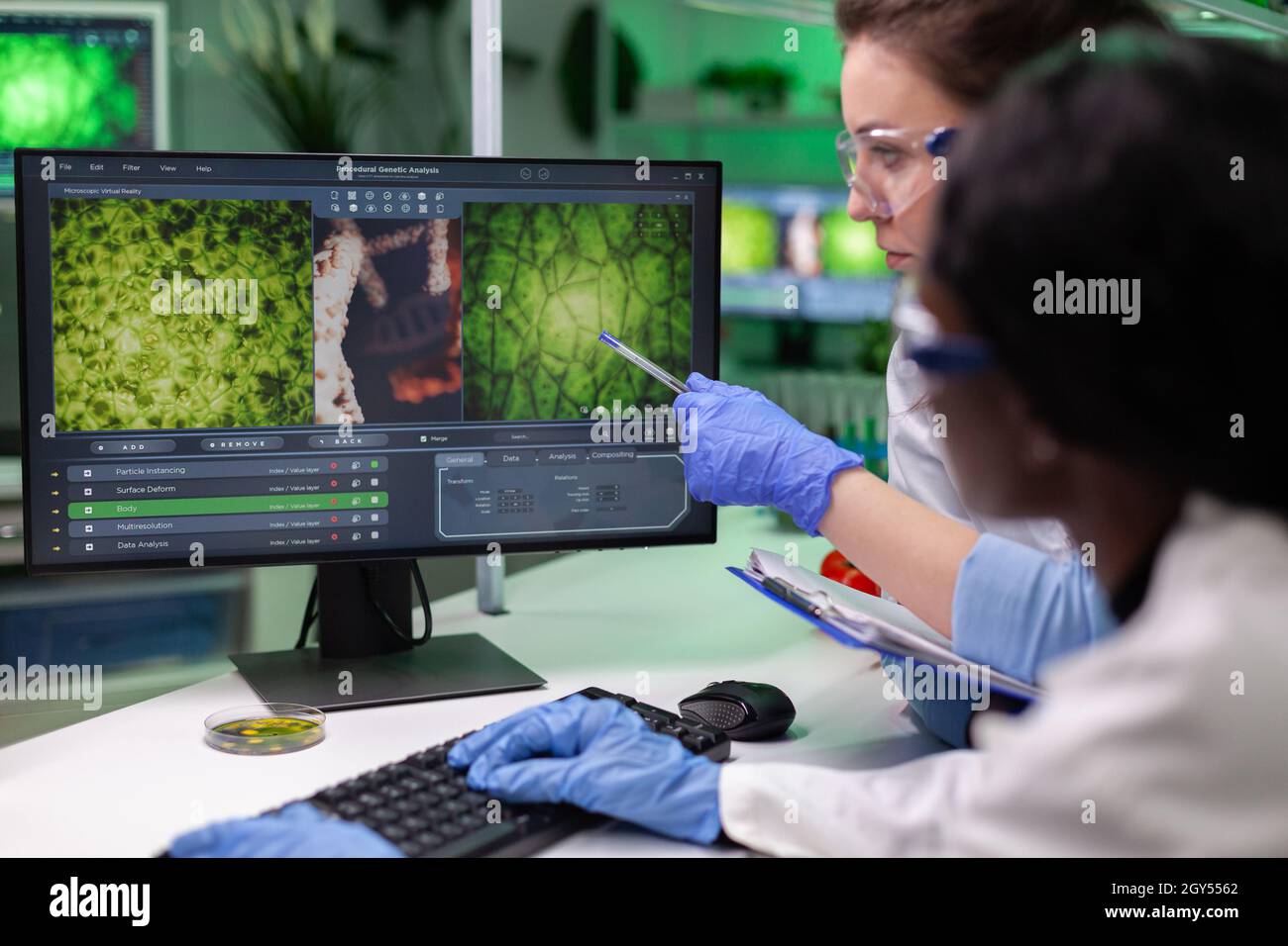 Multi-ethnic team of chemists researchers analyzing plants modified ...